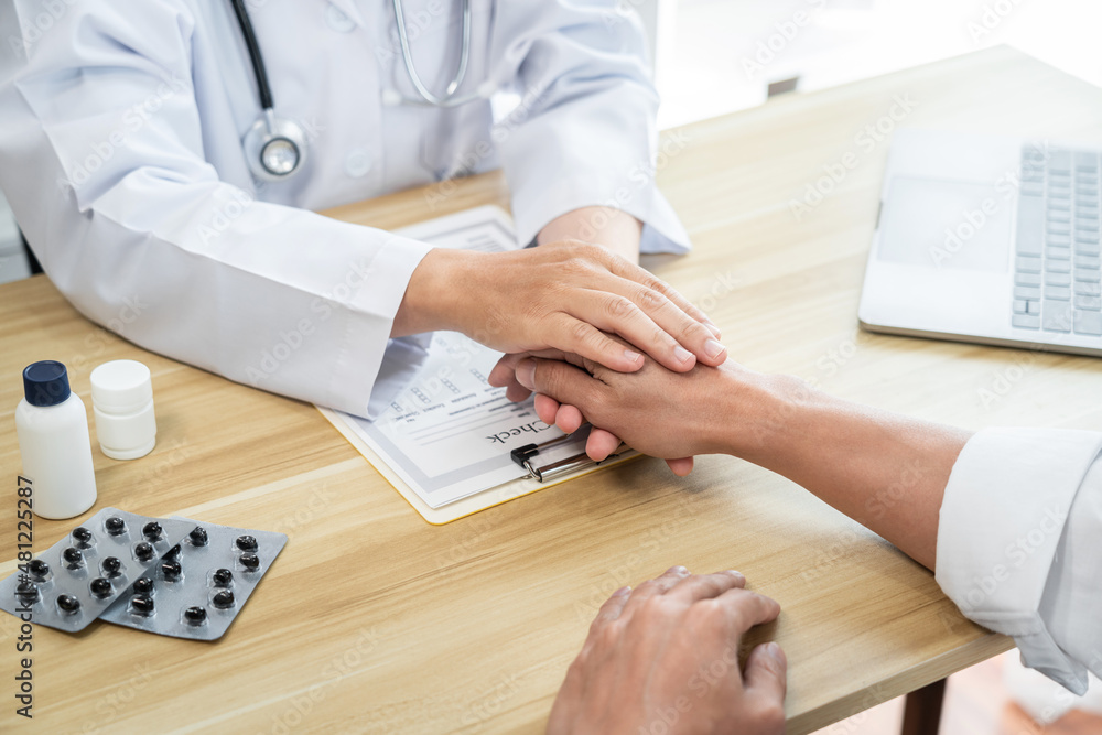 Doctor touching patient hands for encouragement and empathy on the ...