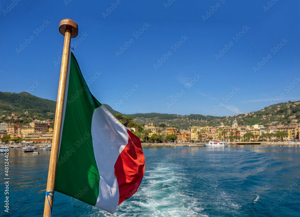 Italian Flag on rear of boat with the Mediterranean coast in the ...