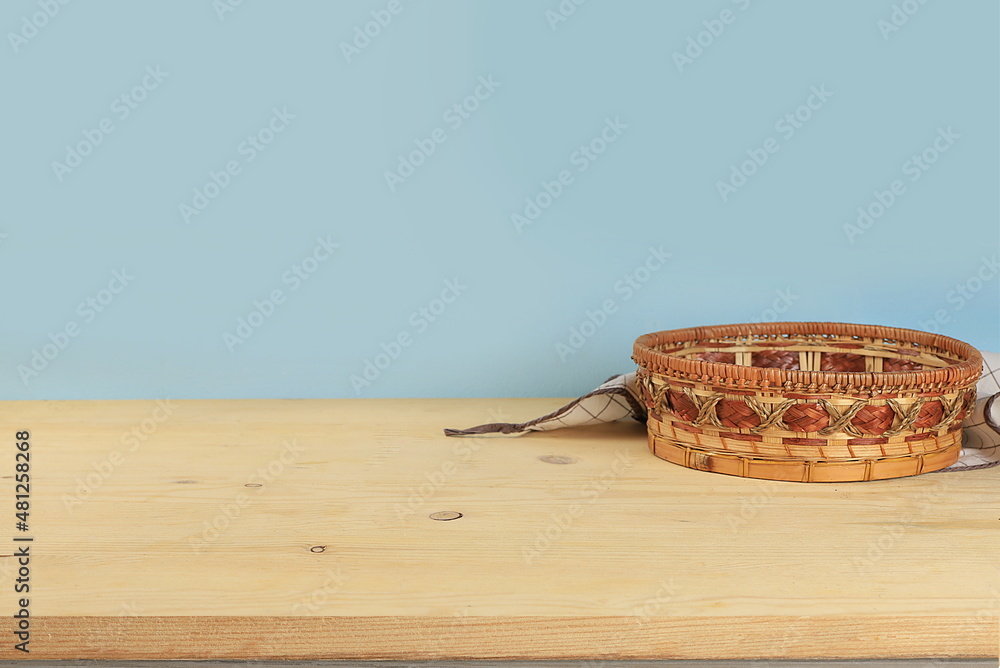 Empty wooden table with wicker basket on old background with space for ...