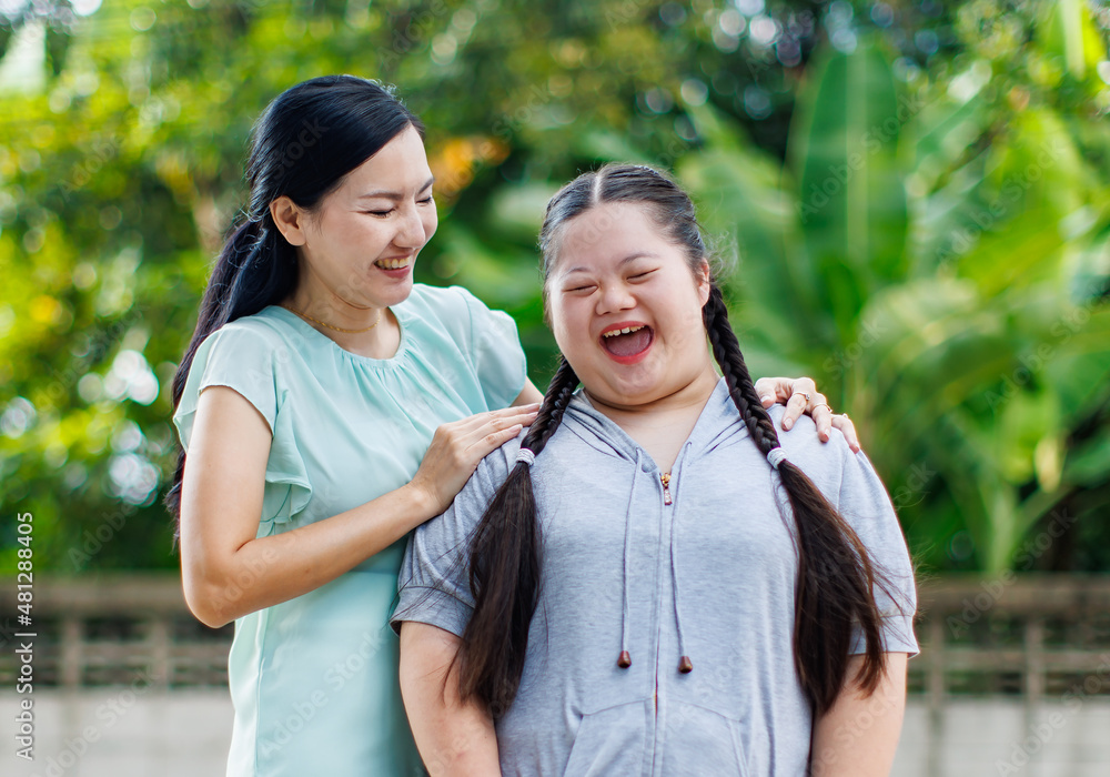 Portrait shot of Asian mother and young chubby down syndrome autistic ...