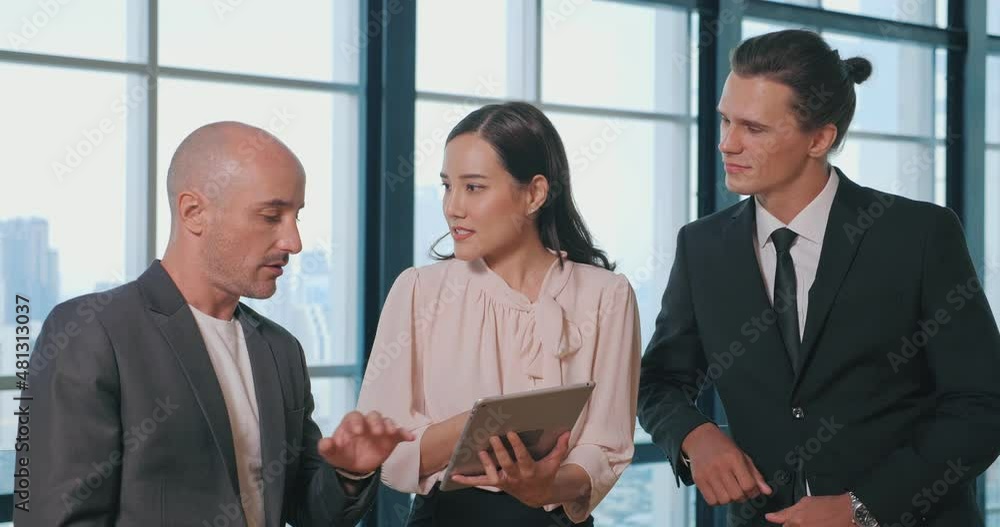 Group of business colleagues looking at laptop screen discussing ...