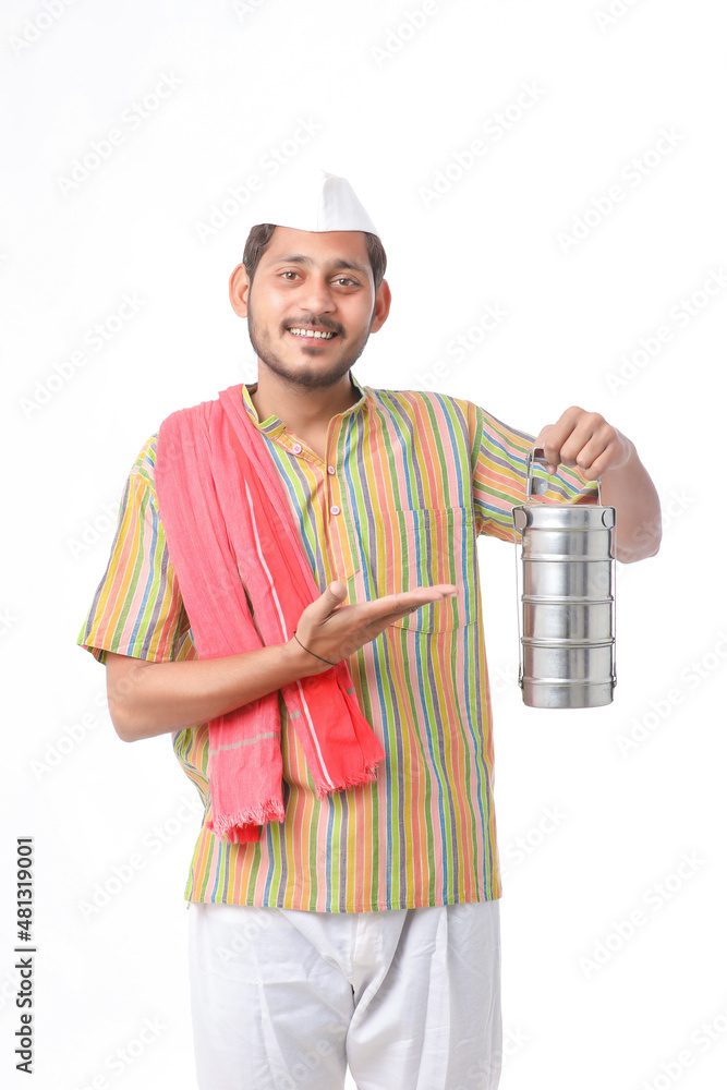 Young indian common man in traditional wear holding tiffin box in hand ...