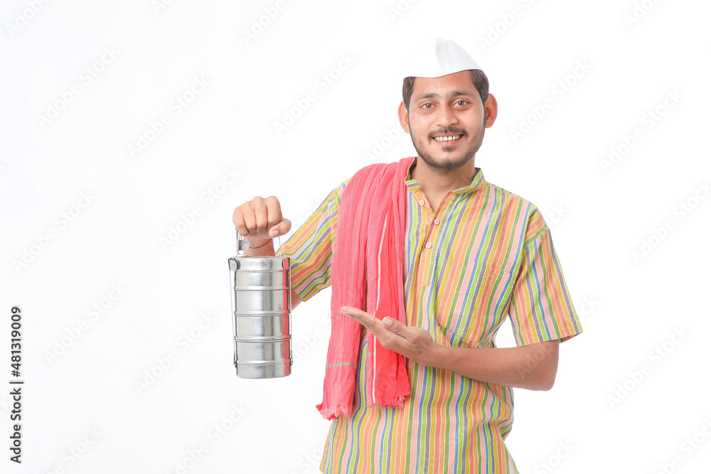 Young indian common man in traditional wear holding tiffin box in hand ...
