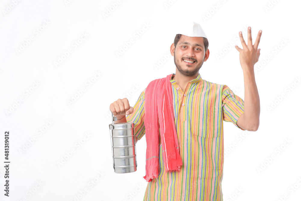 Young indian common man in traditional wear holding tiffin box in hand ...