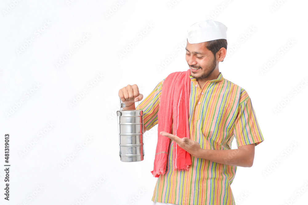 Young indian common man in traditional wear holding tiffin box in hand ...