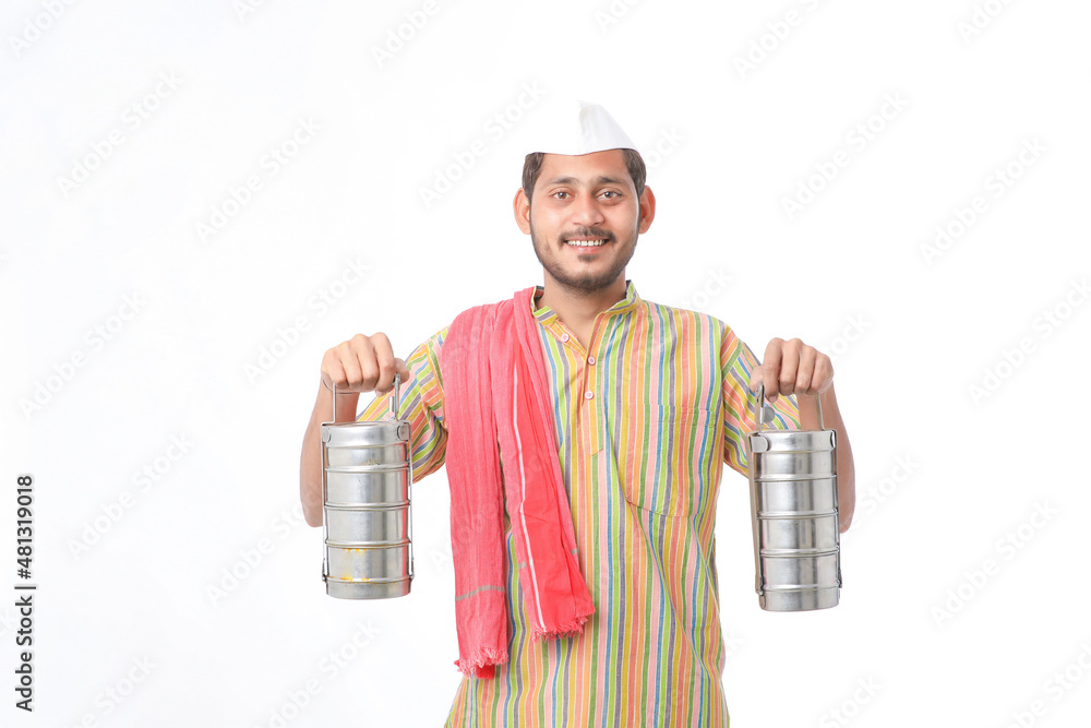 Young indian common man in traditional wear holding tiffin box in hand ...