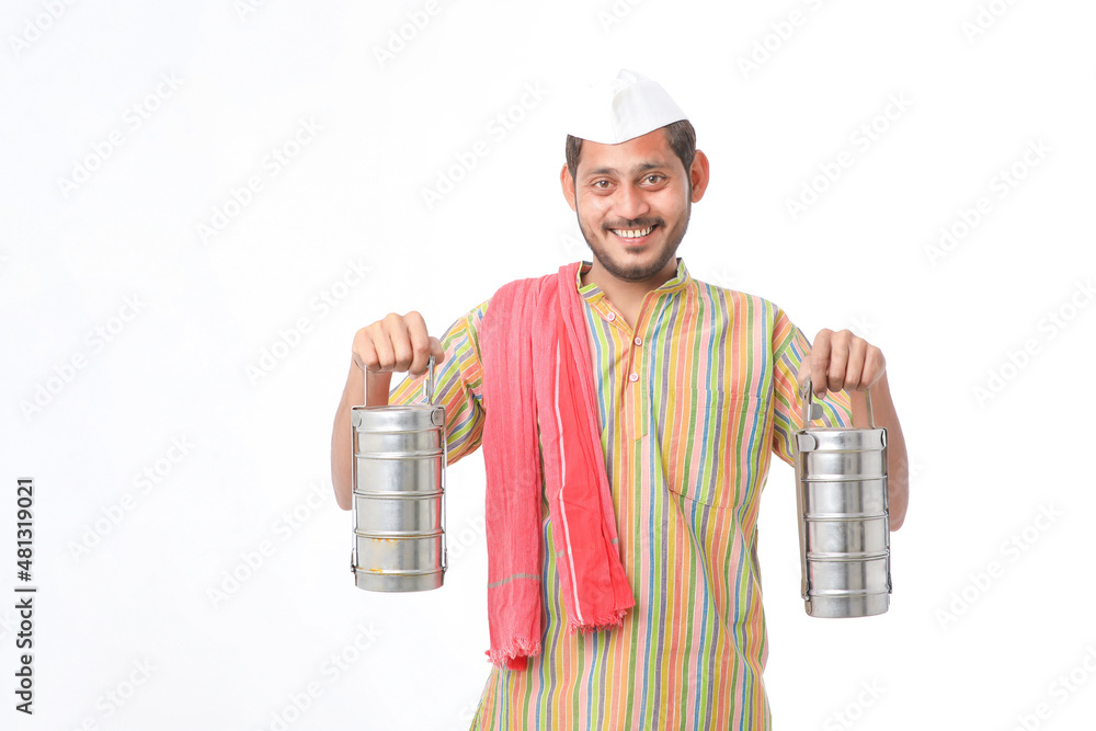 Young indian common man in traditional wear holding tiffin box in hand ...
