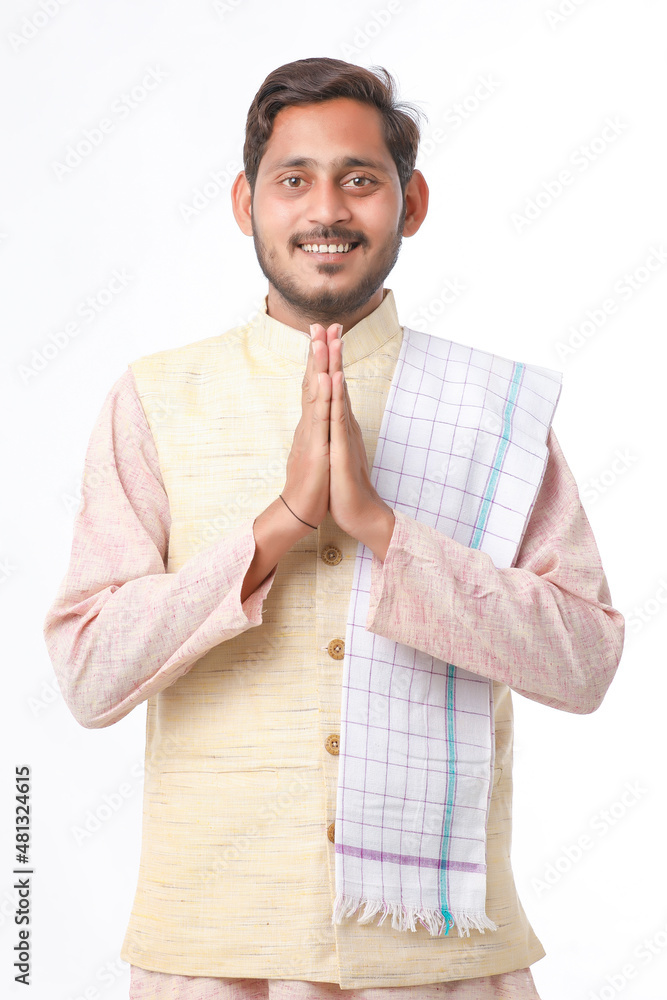 Young indian man in traditional wear and giving namaste or welcome ...