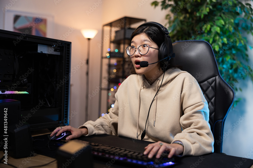 Girl with nerd glasses playing games on the computer, professional ...