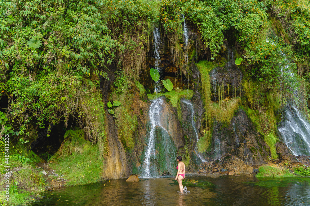Rear full view of unrecognizable woman bathing at thermal springs in ...