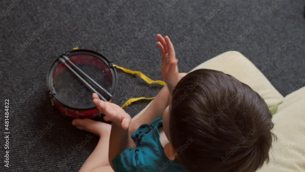 Video. Top view of a boy clapping his hands after playing drums sitting ...
