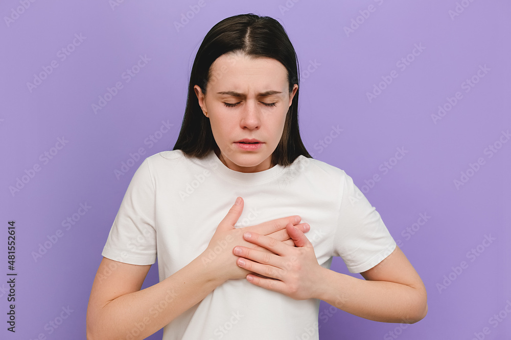 Portrait of disappointed tired young brunette female suddenly touching ...