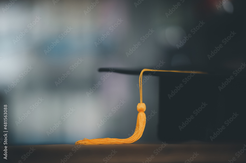 Black Graduation Hat placed on wooden board Stock Photo | Adobe Stock