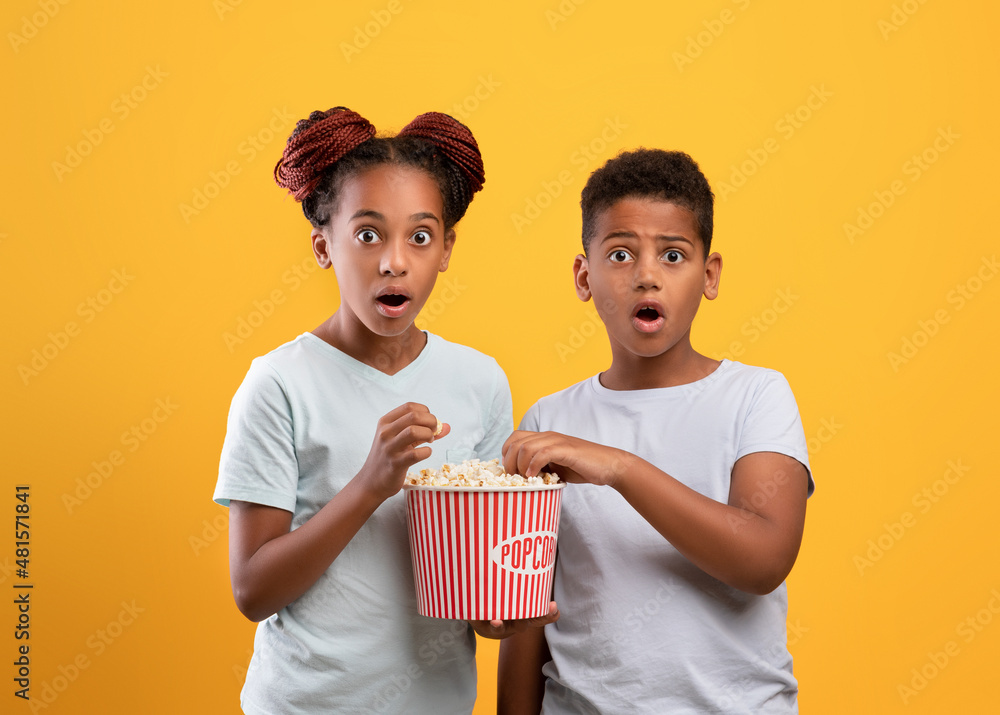 Shocked black kids boy and girl eating popcorn Stock Photo | Adobe Stock