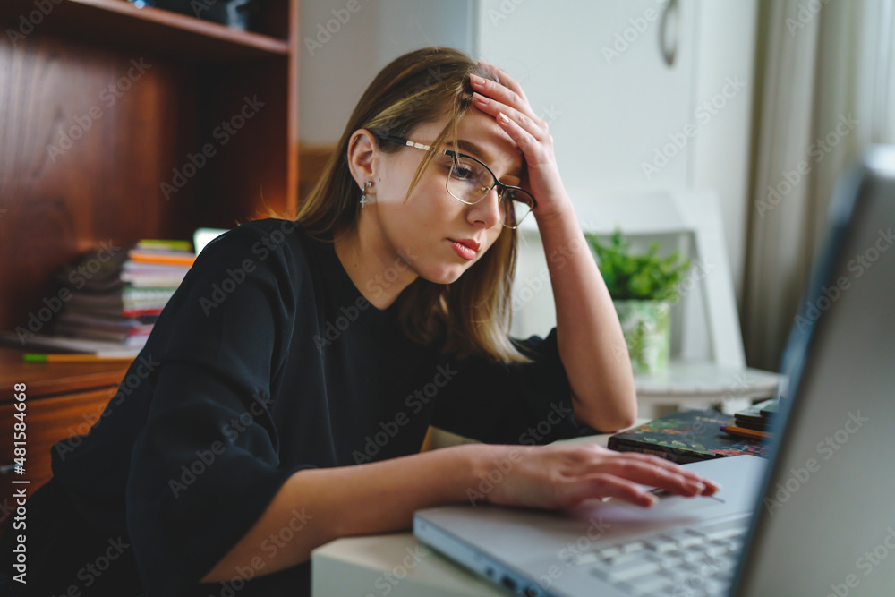 One woman young female working on laptop computer tired and sad having ...
