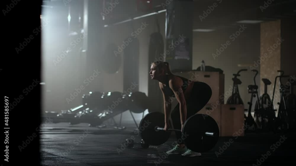 Female bodybuilder doing exercise with weights in gym. a female ...