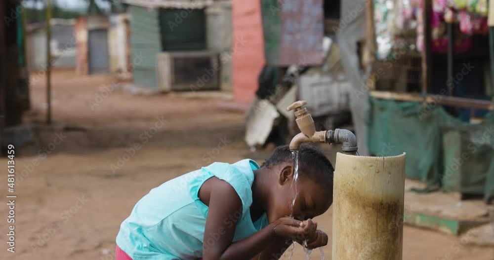 Poverty.Inequality.Poor black african girl drinking water from a ...