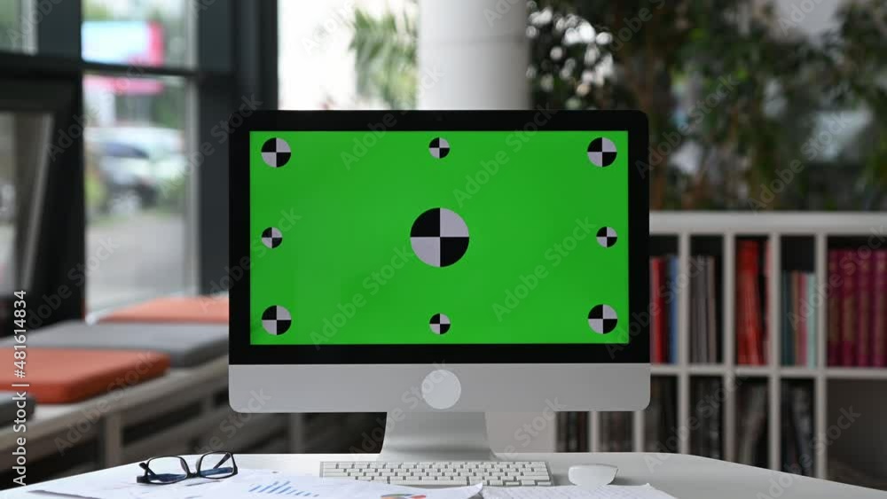 Computer with green screen mockup display standing on work desk in a ...