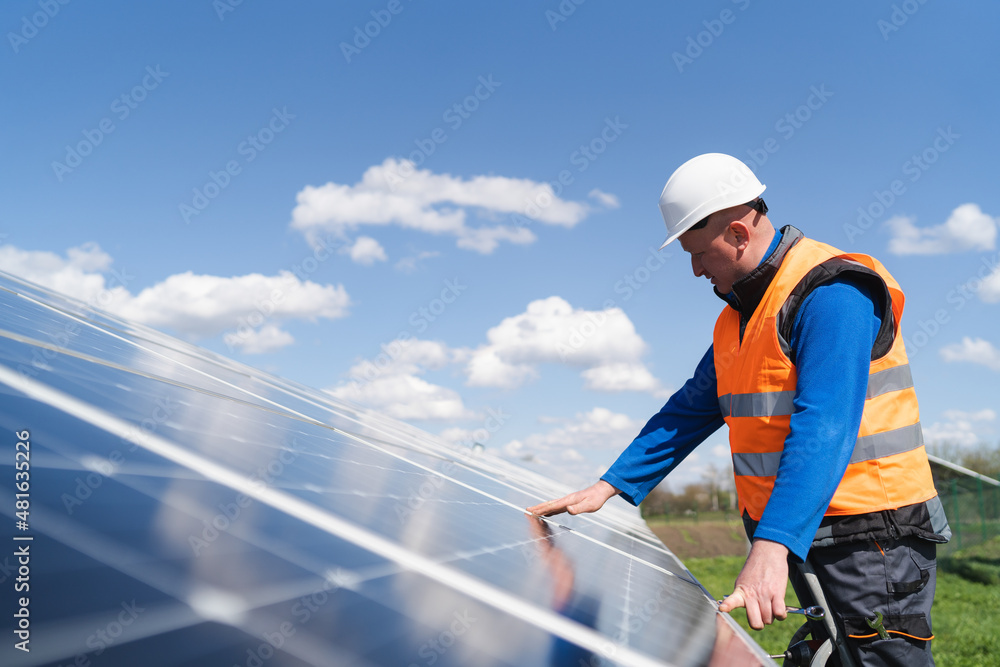 Solar power plant engineer makes a visual inspection of solar panels ...