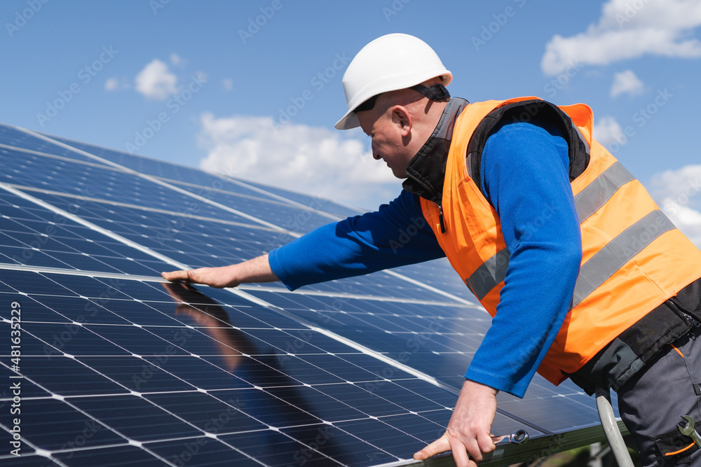 Solar power plant engineer makes a visual inspection of solar panels ...