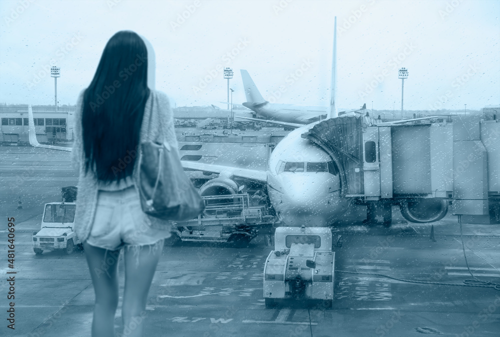 Woman waiting for flight in modern airport terminal building, watching ...