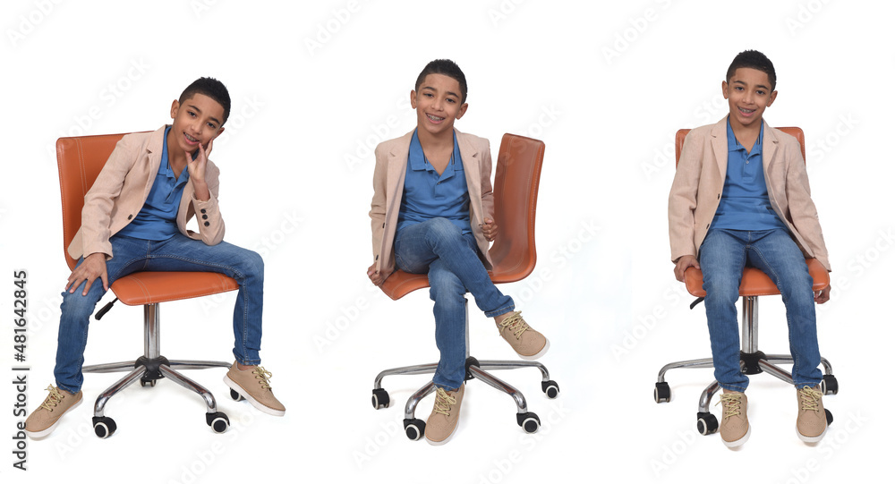 set of same boy who is sitting on a chair looking at camera on white ...