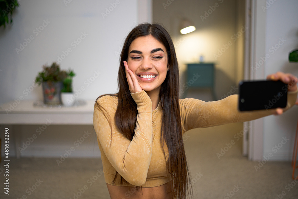 Pretty young female with big smile at her home having fun taking light ...