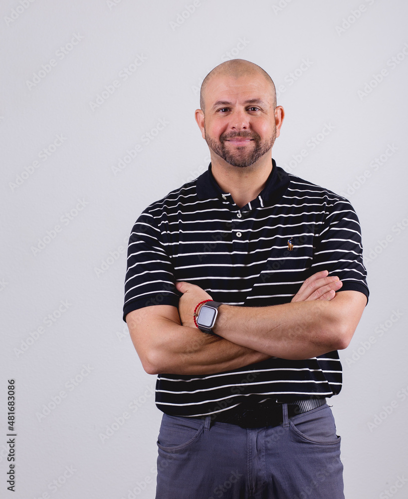 Hispanic bald man standing in front of a white background and making ...