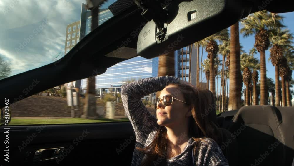 Happy girl smiling in a convertible car. Woman smiling on a road trip ...