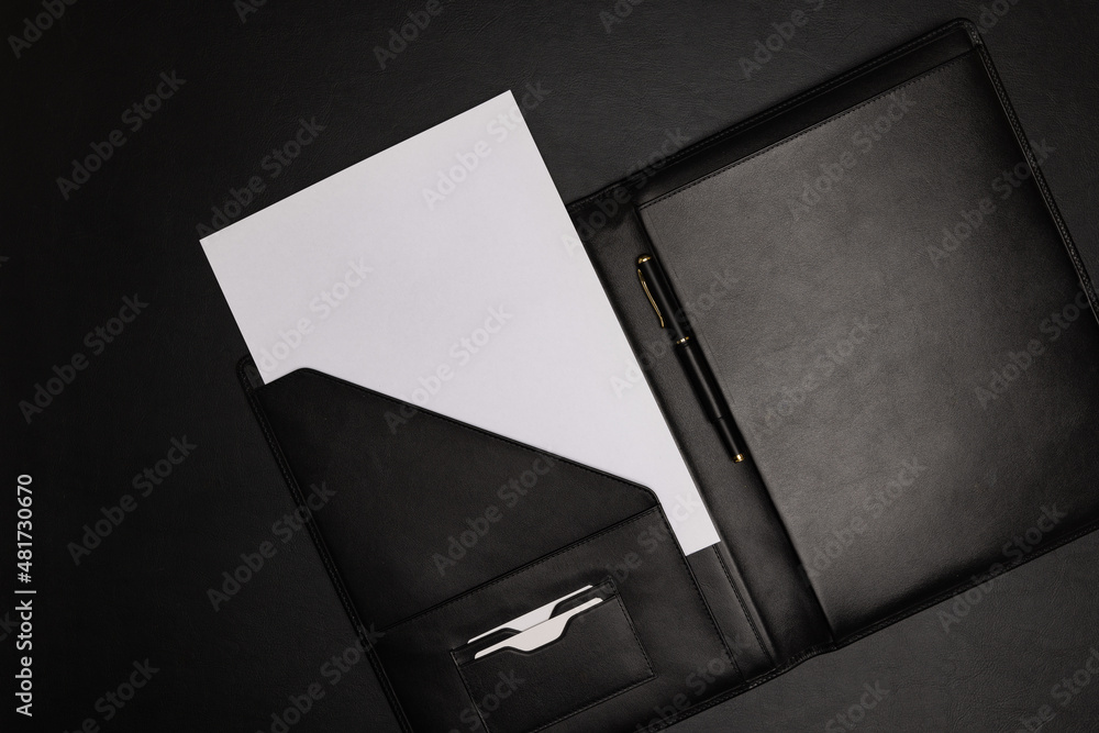 Black leather file folder agenda organizer opened with white blank ...