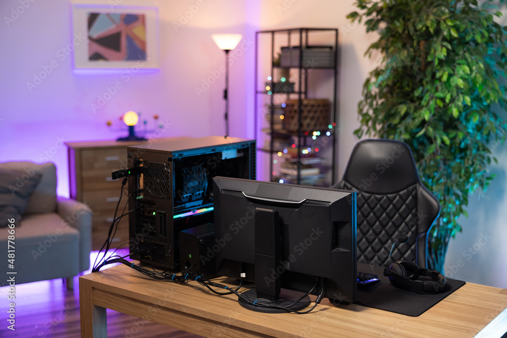 A backlit professional computer for a gamer. The monitor stands on a ...