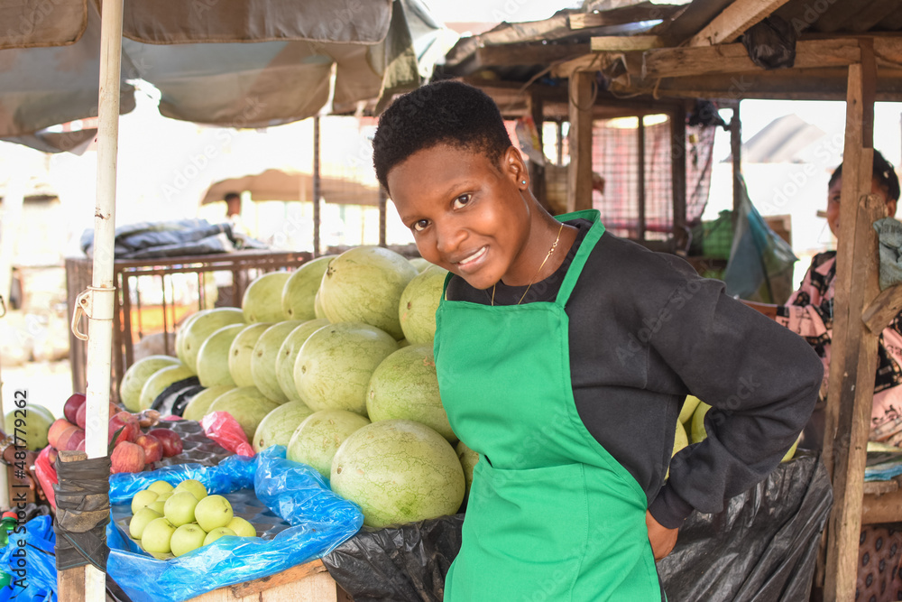 African woman or female trader with a green apron, standing at her ...