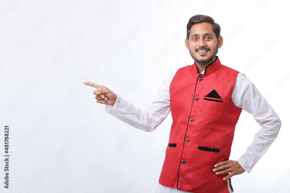 young indian man in traditional wear and showing direction on white ...