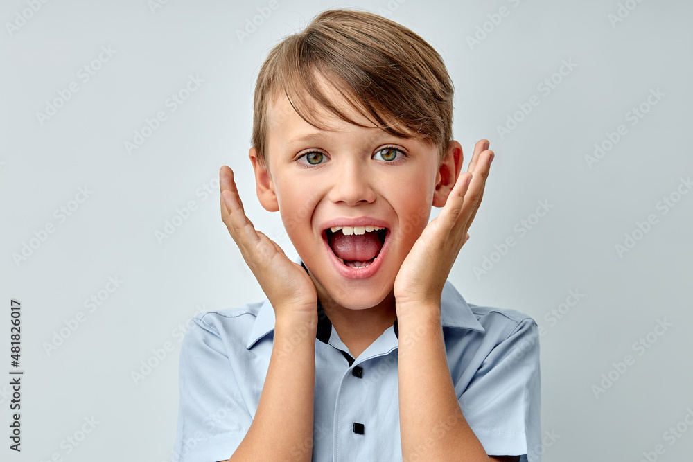 emotional little boy amazed touching face with opened mouth isolated ...