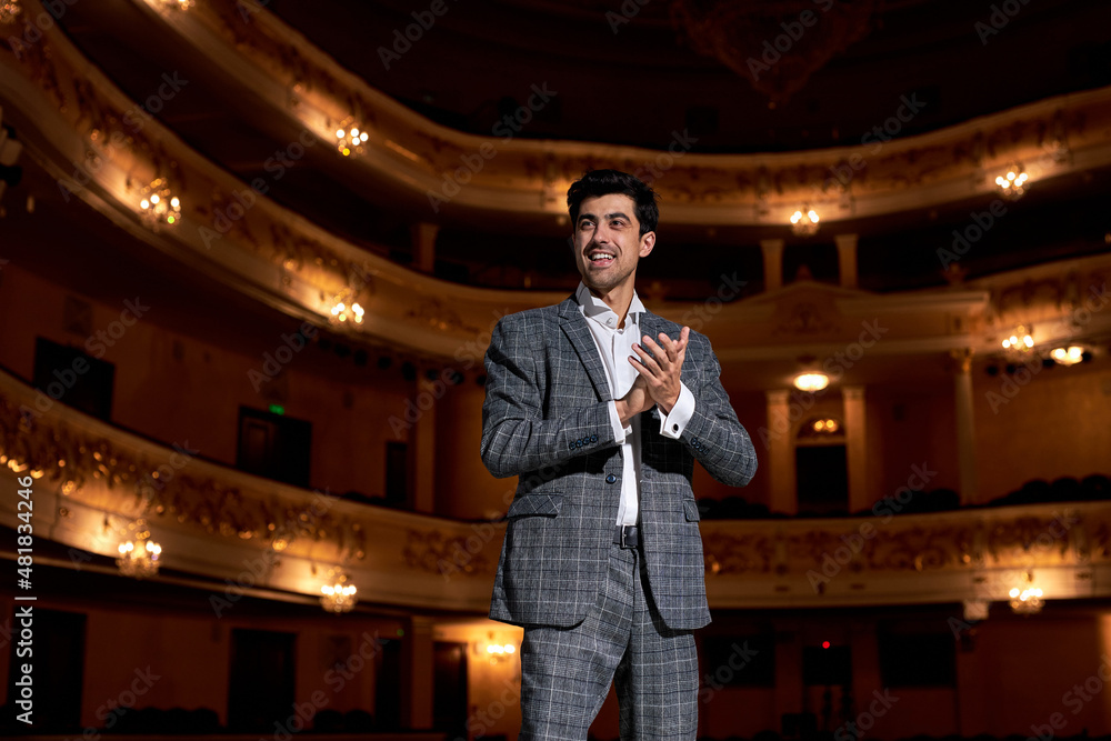 Actor or business couch standing on stage clapping hands, keep hands ...
