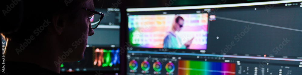 Back view of a young white man video editor Stock Photo | Adobe Stock
