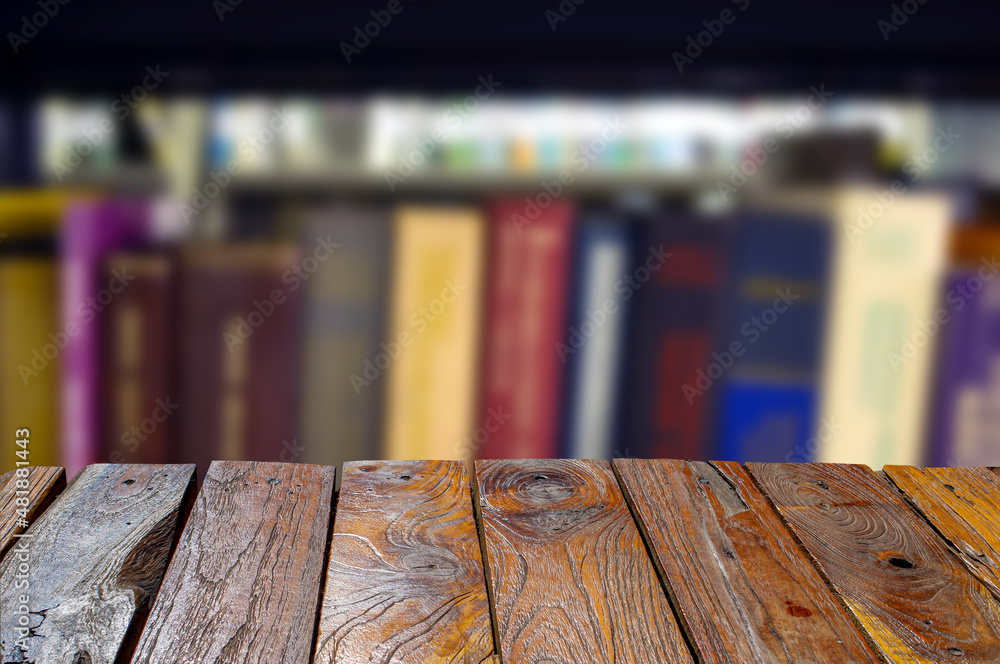 Old teak wood empty table with defocused old books on the bookshelves ...