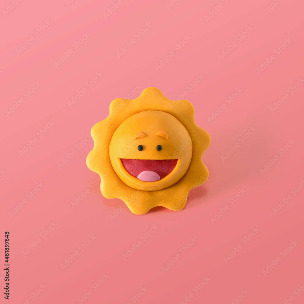 Smiling cartoon sun made by hand from plasticine on a pink background ...