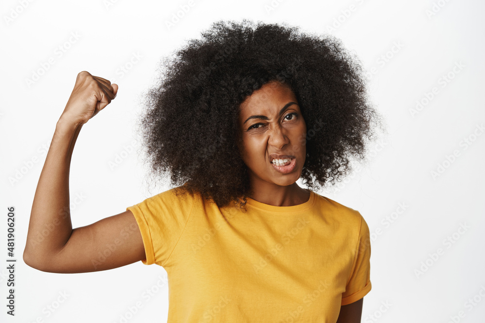 Women power. Strong and powerful african american woman flexing biceps ...