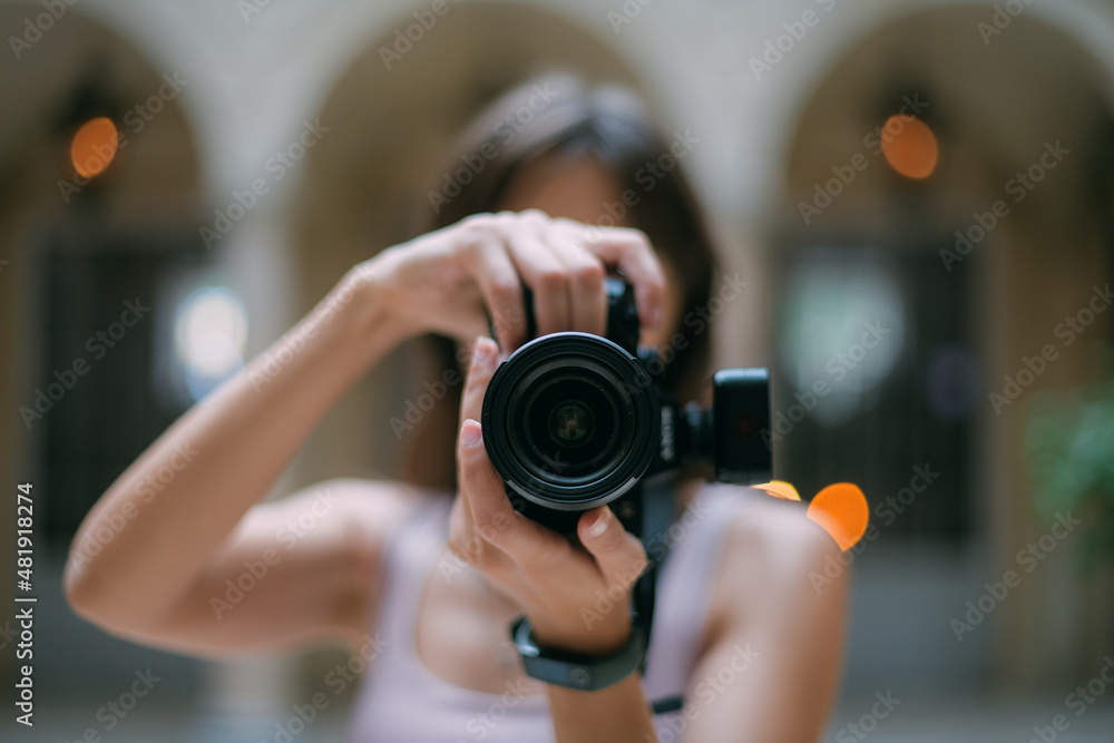 Girl photographer with a camera at work on the set in the studio room ...