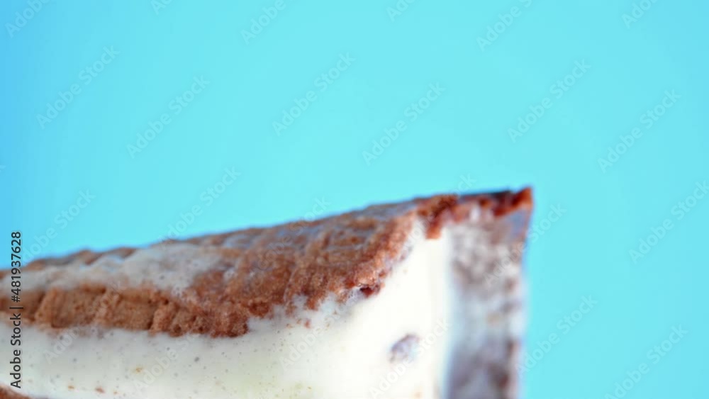 side pan melting ice cream cone of vanilla flavor close up on a blue ...