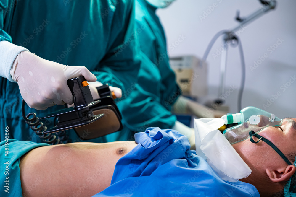 Selective focus at defibrillator while doctor use it to pump at chest ...