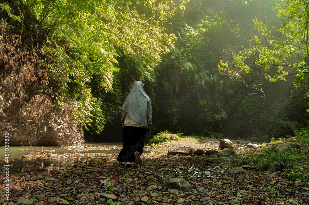 Muslimah girl walking alone in Tahura Djuanda Bandung City National ...