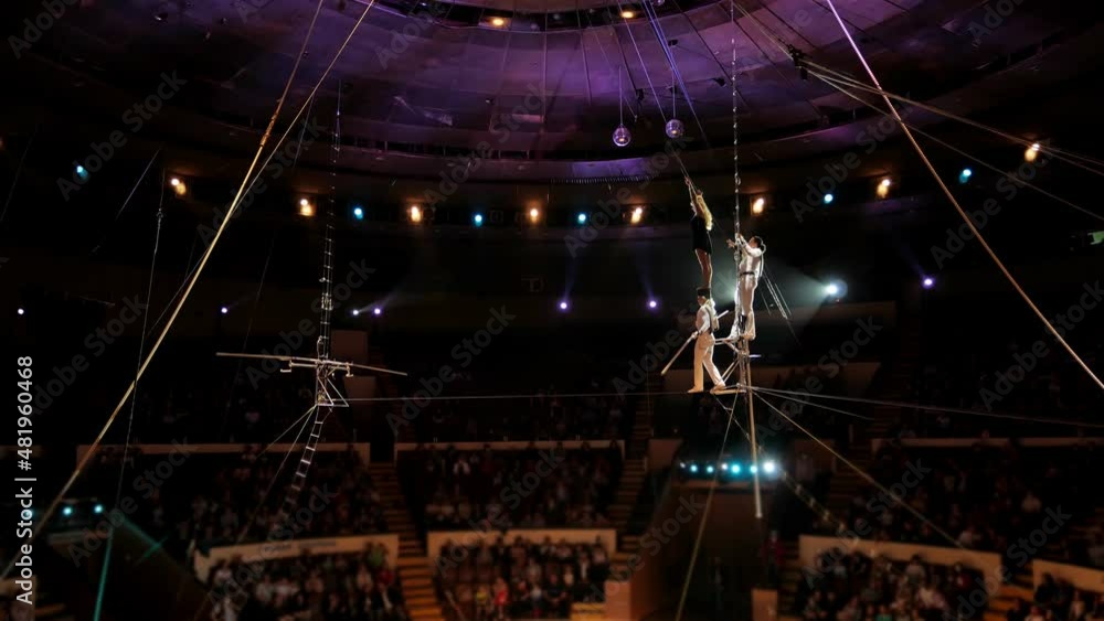 Performance of three aerial tightrope walkers gymnasts in white suits ...