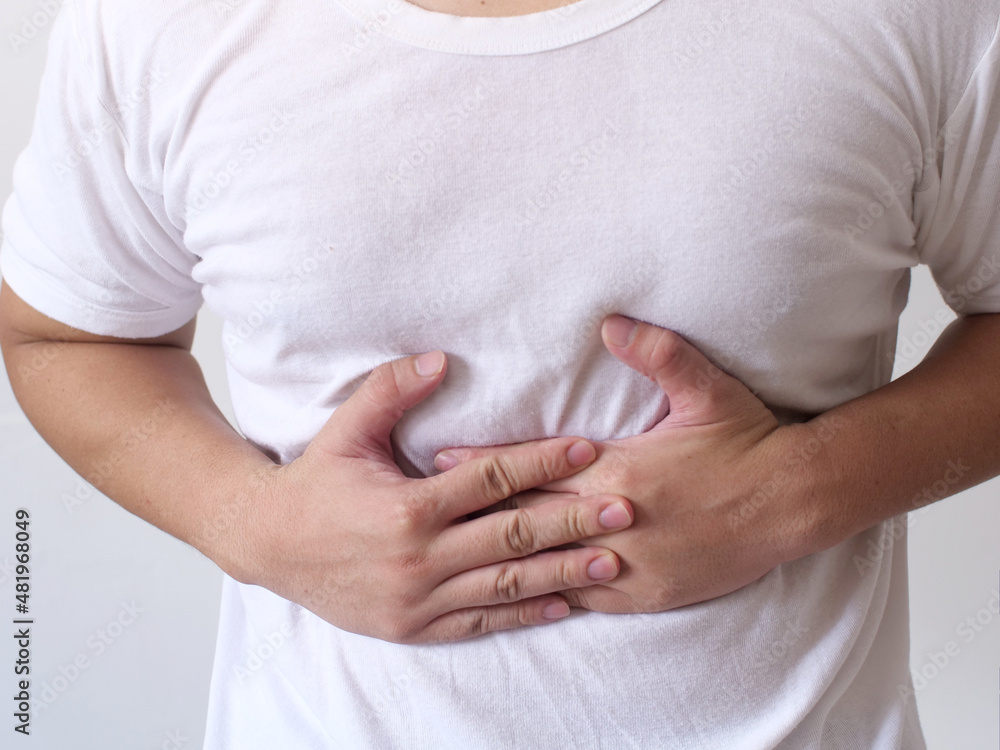 Anonymous person pushing his belly with hands due to stomach cramp pain ...