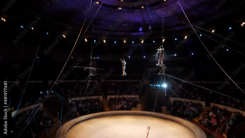 Performance of three aerial tightrope walkers gymnasts in white suits ...