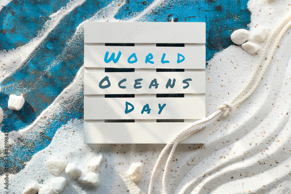 World Oceans Day text. Sand frame, seashells, starfish, cord. Text on ...