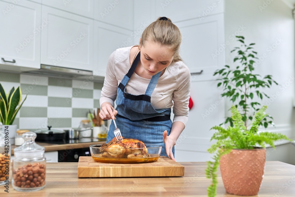 Woman cooking baked chicken at home in the kitchen. Stock Photo | Adobe ...