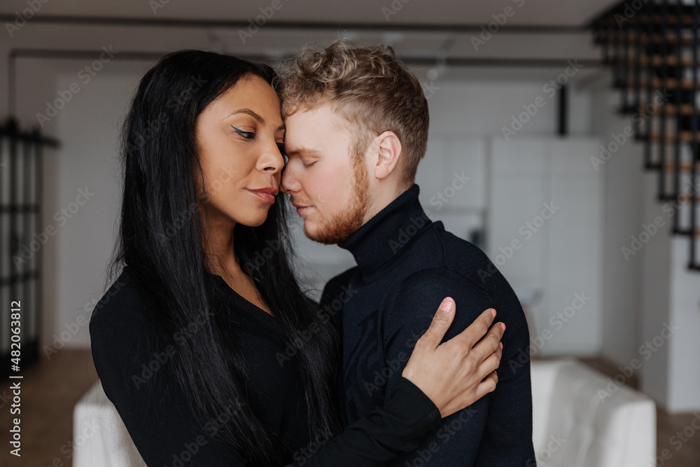 Young husband gently hugs his wife in the living room Stock Photo ...