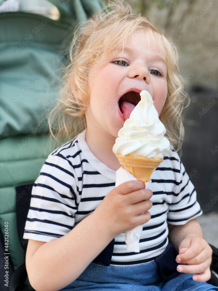 Cute funny preschool girl eating fruit ice cream. Happy healthy toddler ...